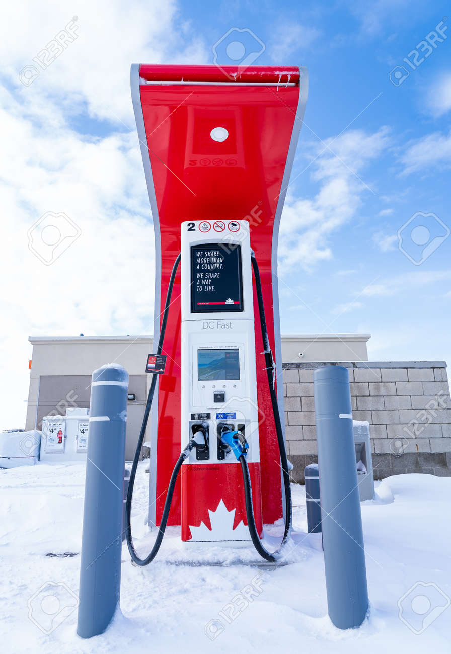 Rocky View County Alberta Canada April 20 2022 Ice An Snow Covered Petro Canada Fast Charge EV Charging Station For Canada s Electric Highway Network At Cross Iron Mills Shopping Center. Stock Photo