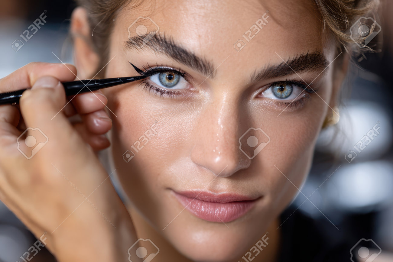 A Makeup Artist Applies Eyeliner To A Model's Eyes For A Fashion Show ...